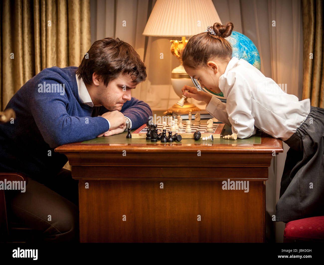 Man lost chess game with smart little girl Stock Photo - Alamy