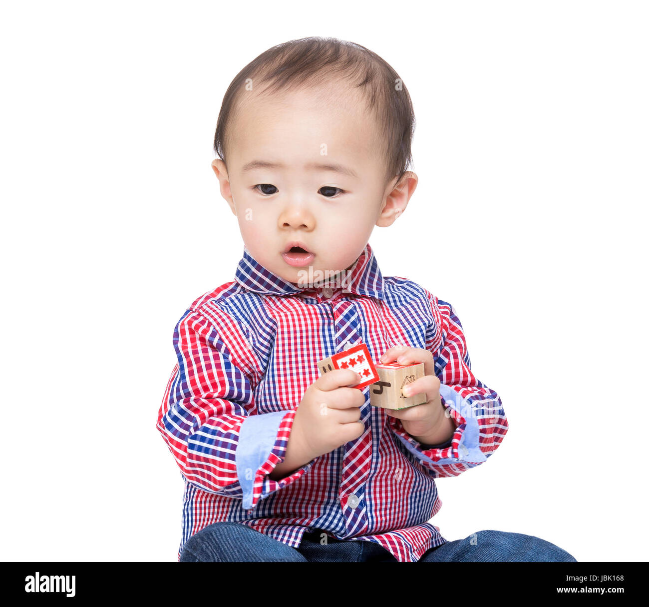 Little boy holding wooden toy block and looking aside Stock Photo - Alamy