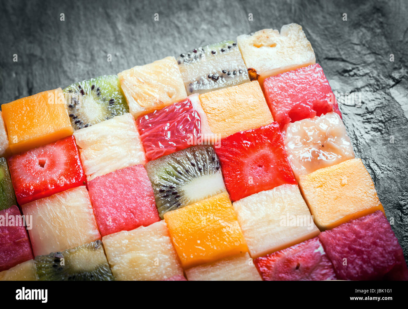 Cubed tropical fruit arranged in a decorative colorful square with a ...