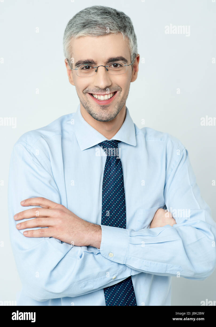 Confident businessman crossed arms over white background Stock Photo ...