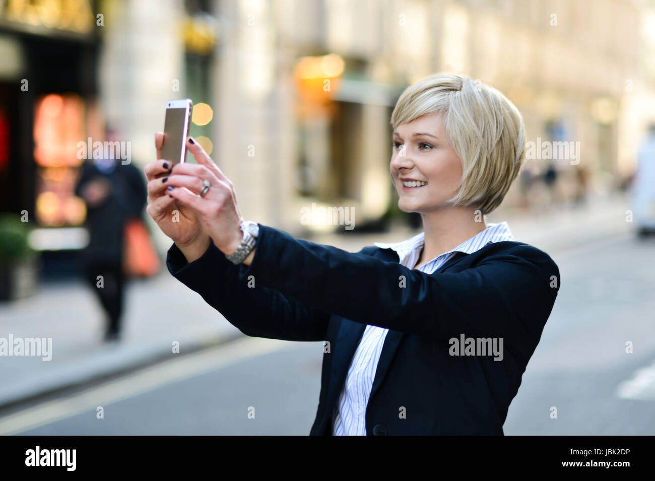 Corporate lady clicking her pic, outdoors Stock Photo - Alamy