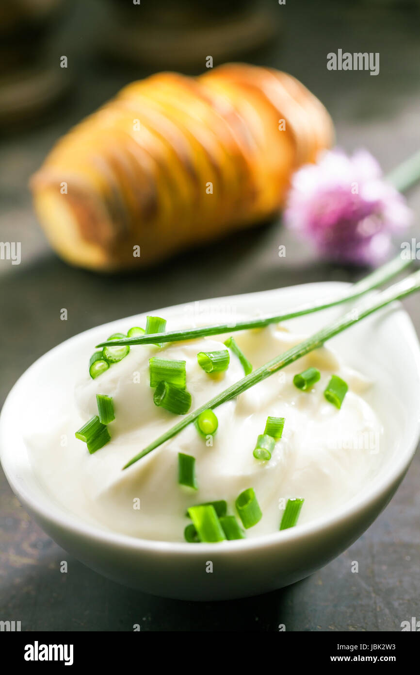 Plate of chopped fresh chives with two whole leaves ready to be used as ...