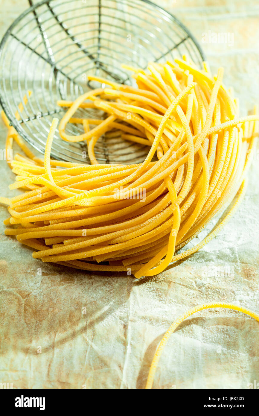 Cooked Italian spaghetti on an old wire kitchen strainer being prepared ...