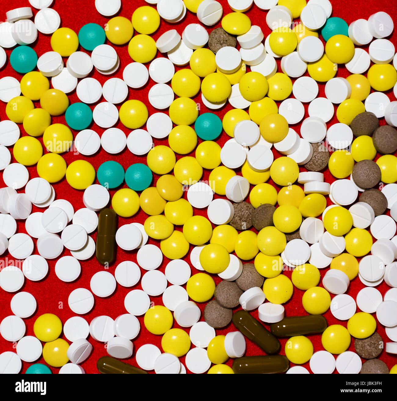 large pile of different pills on a red fabric background Stock Photo ...