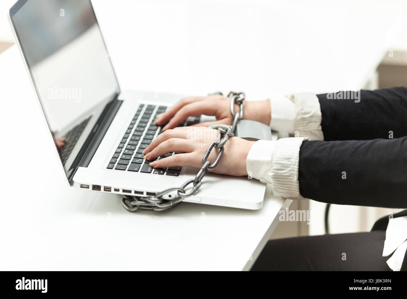 Closeup photo of businesswoman locked to laptop by chain Stock Photo ...