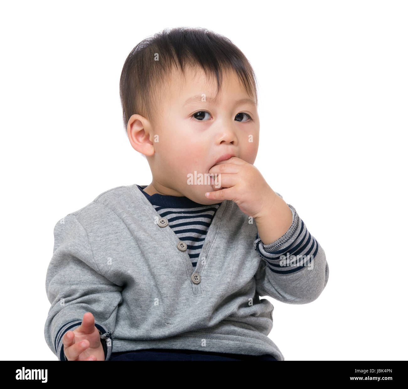 Little boy biting his finger Stock Photo - Alamy