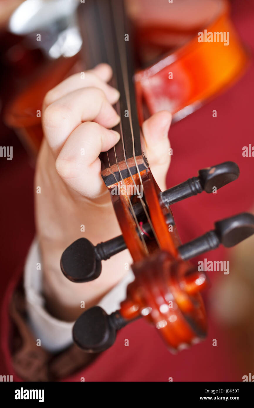 girl plays on fiddle - chord on fingerboard close up Stock Photo - Alamy