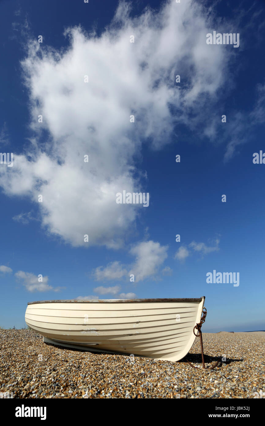 Small rowing boat pulled up onto the shingle beach at Salthouse in ...