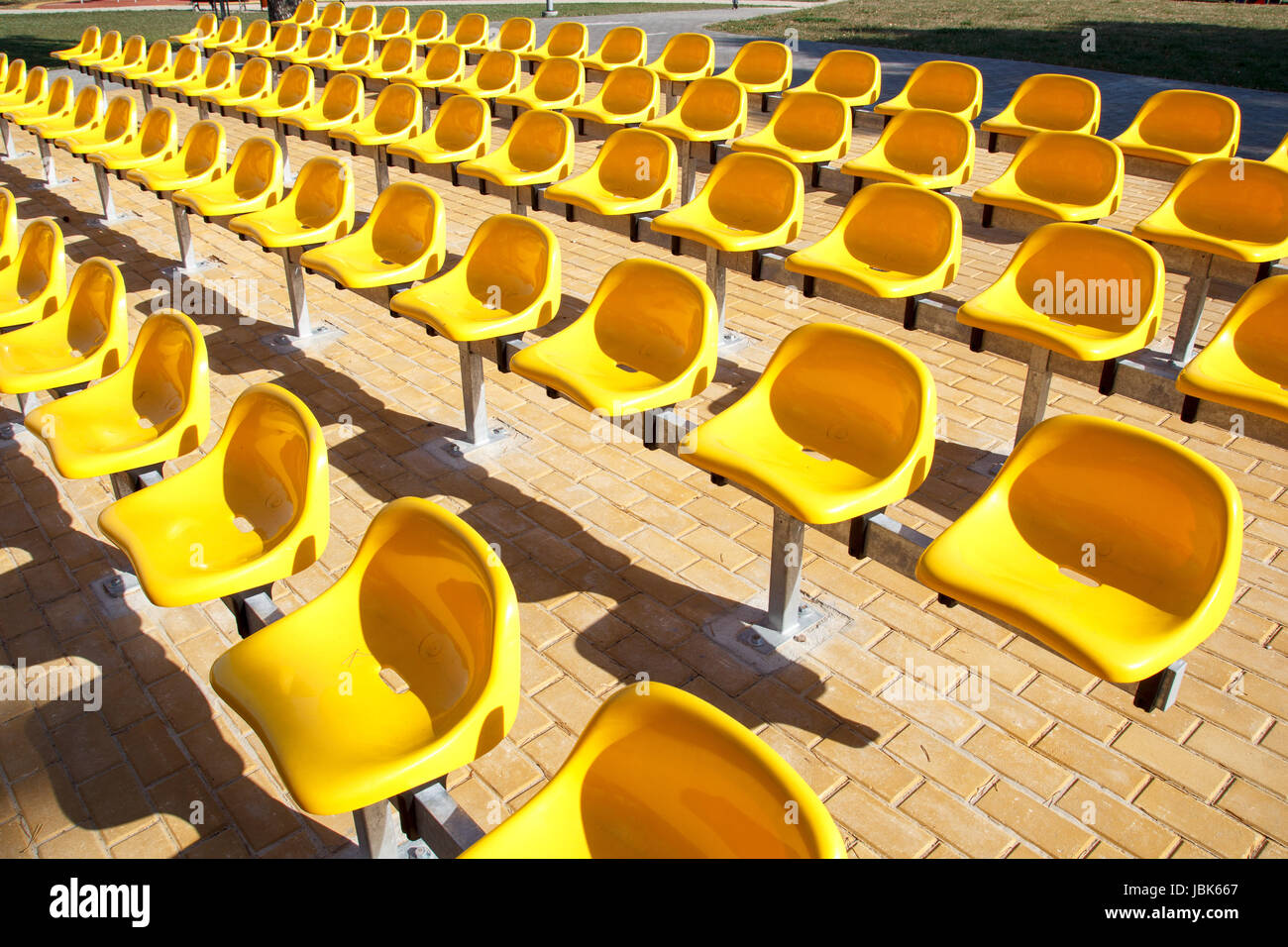 A load of yellow sitting benches in a park Stock Photo - Alamy