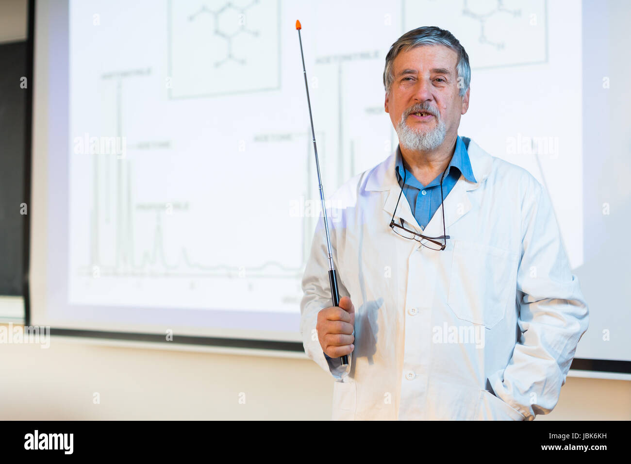 Senior chemistry professor giving a lecture in front of classroom full ...