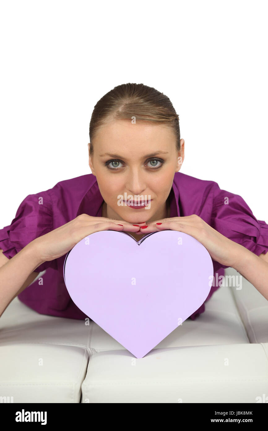 Young woman lying with heart-shaped box Stock Photo - Alamy