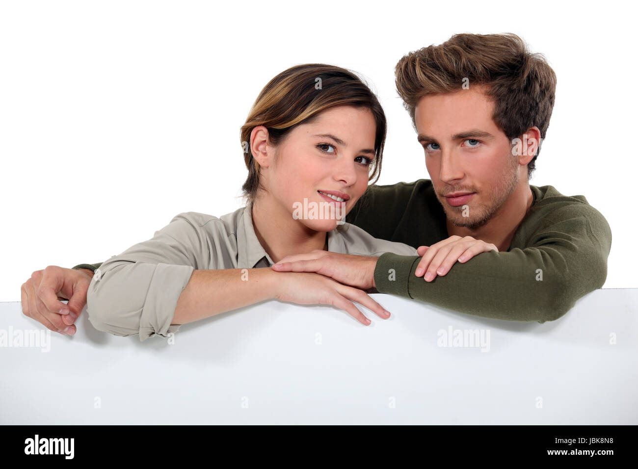 Couple leaning against a blank poster Stock Photo - Alamy