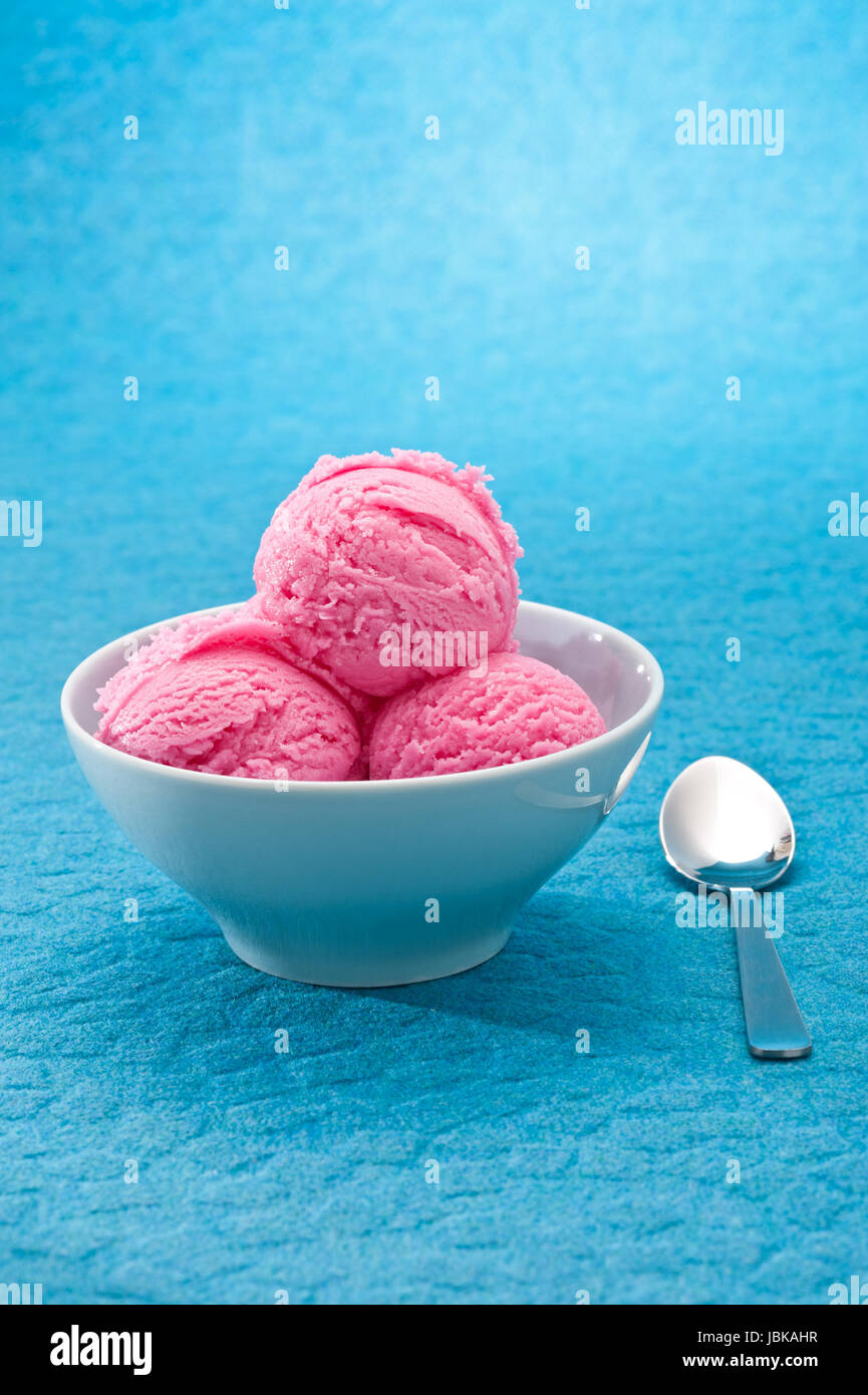 Raspberry ice cream cup over bBLUE background Stock Photo - Alamy