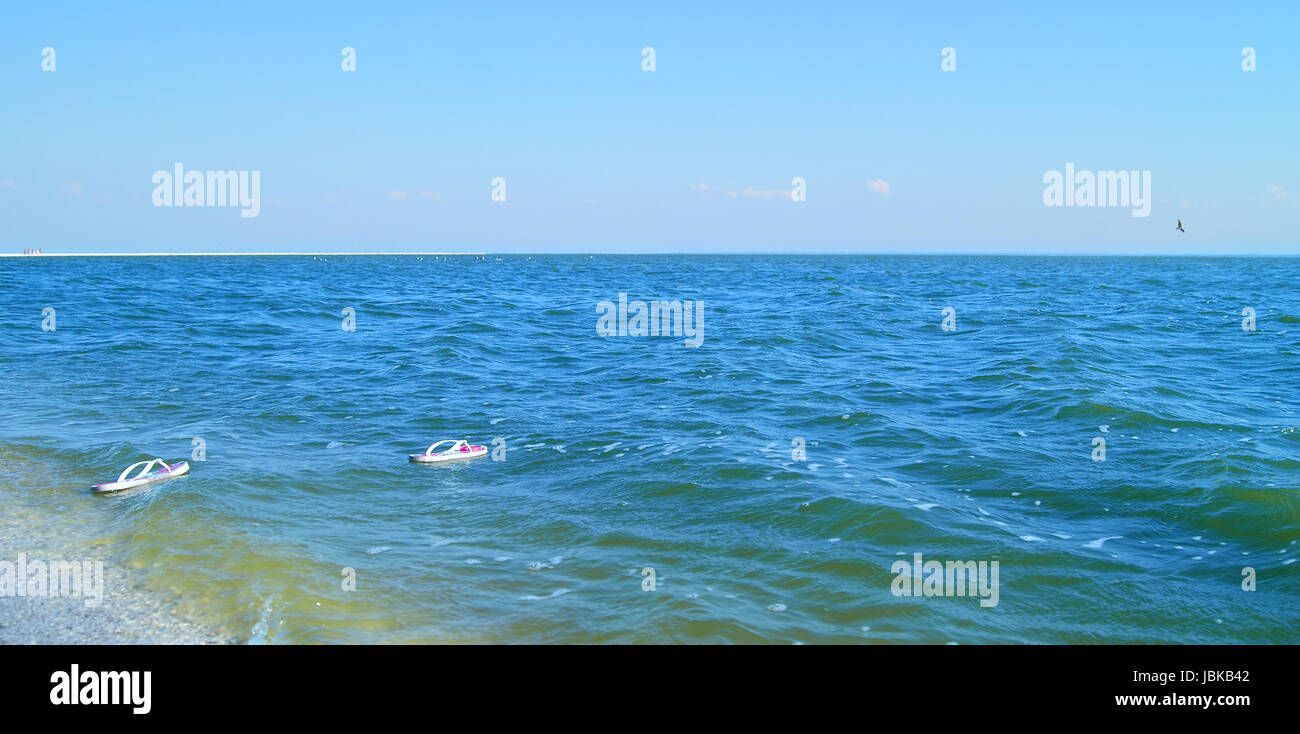 Pair of white flip-flops floating in the ocean Stock Photo - Alamy