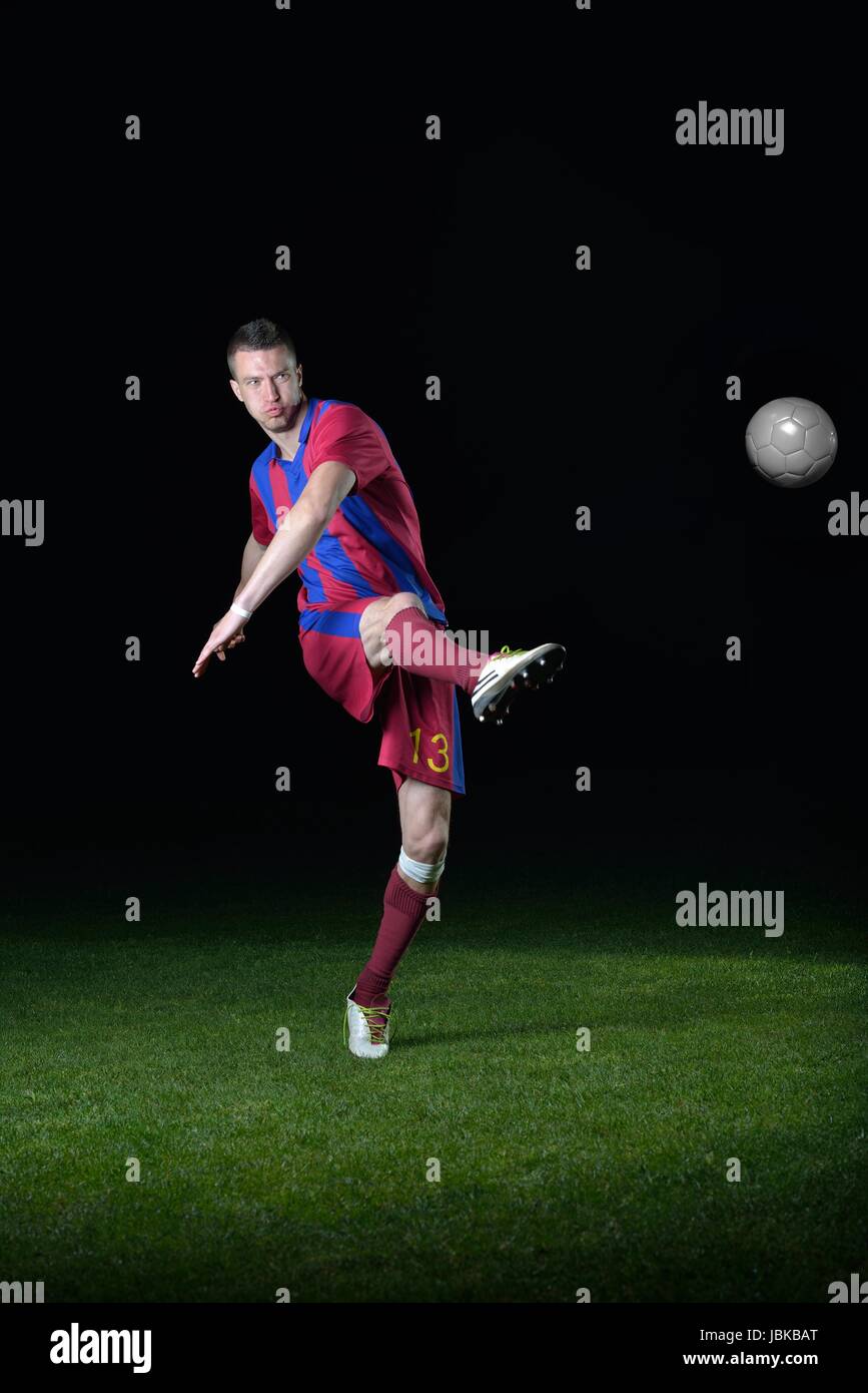 soccer player doing kick with ball on football stadium field isolated ...