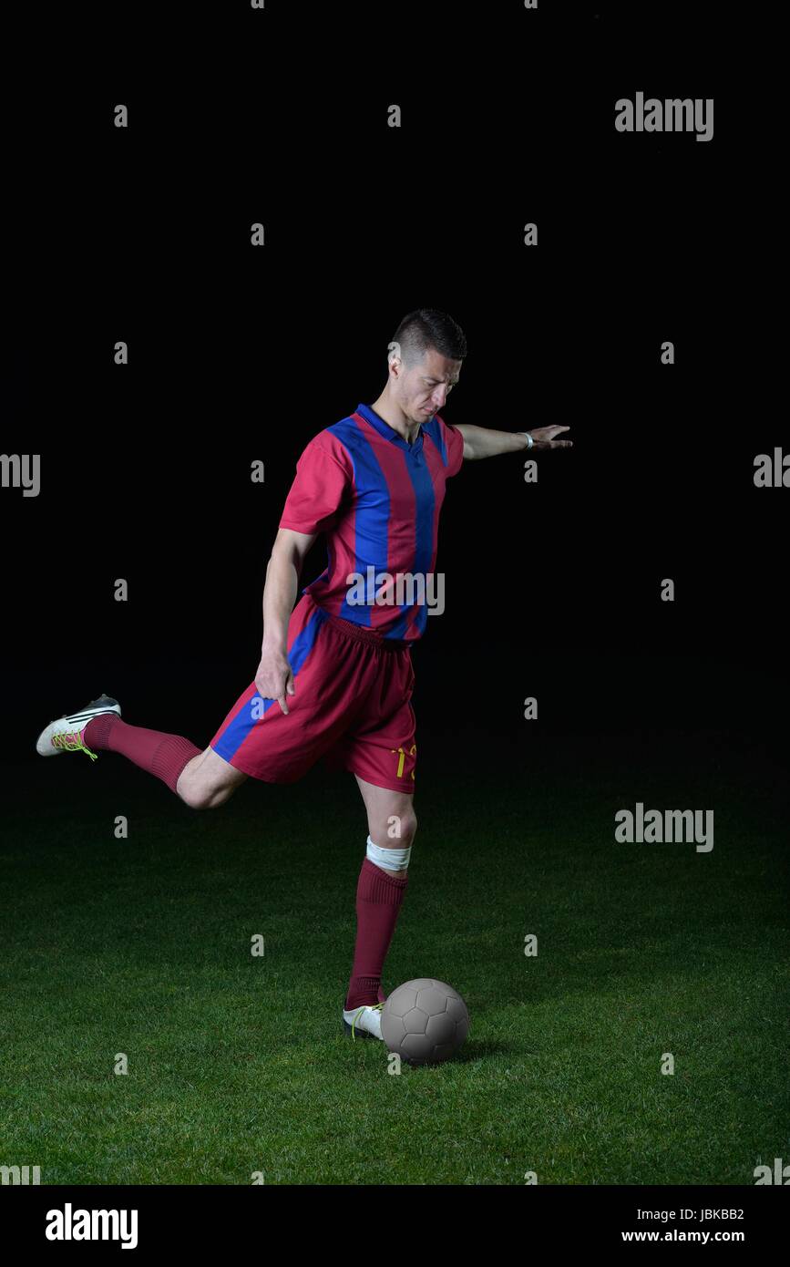 soccer player doing kick with ball on football stadium field isolated ...