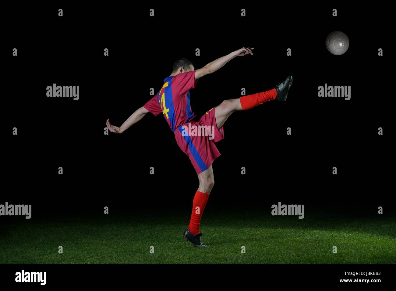 soccer player doing kick with ball on football stadium field isolated ...