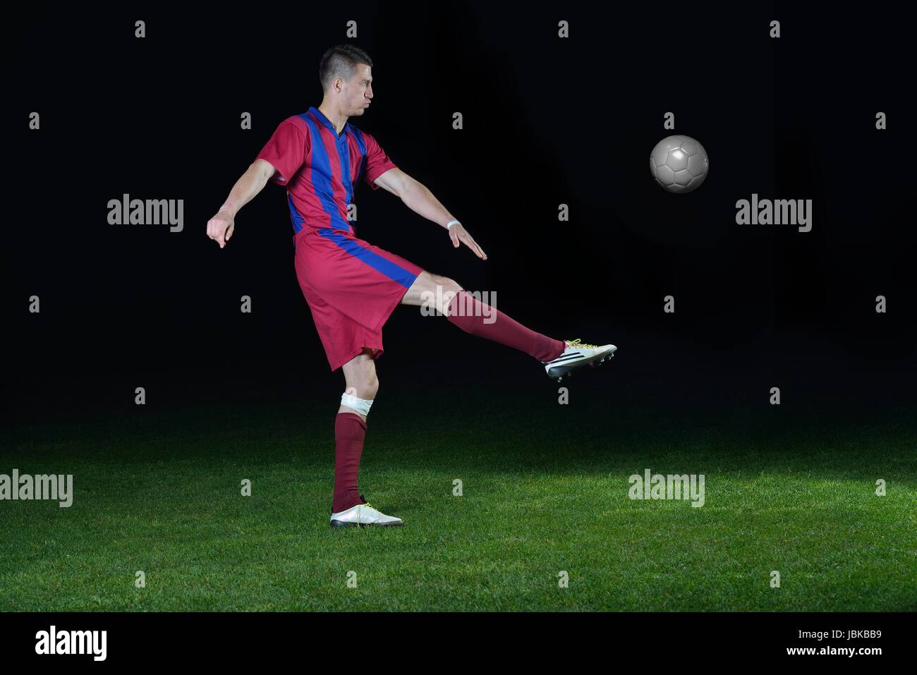 soccer player doing kick with ball on football stadium field isolated ...