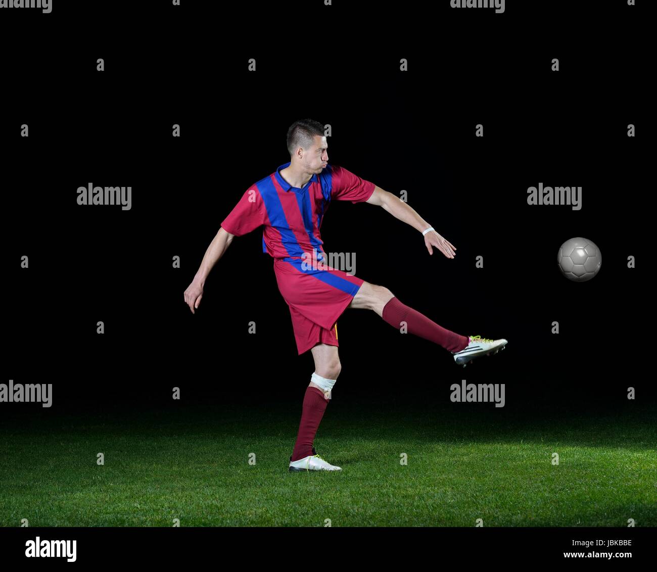 soccer player doing kick with ball on football stadium field isolated ...