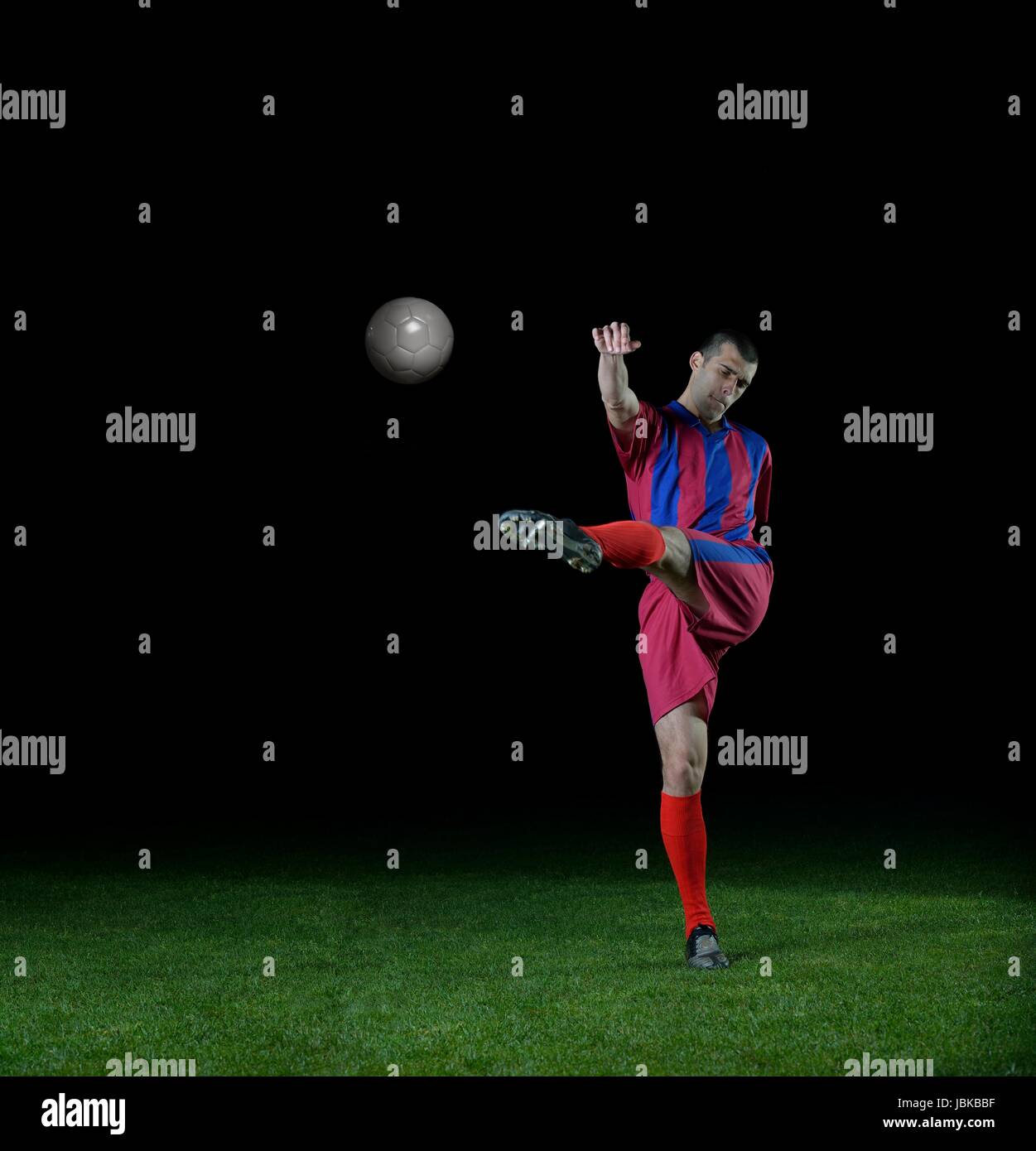 soccer player doing kick with ball on football stadium field isolated ...