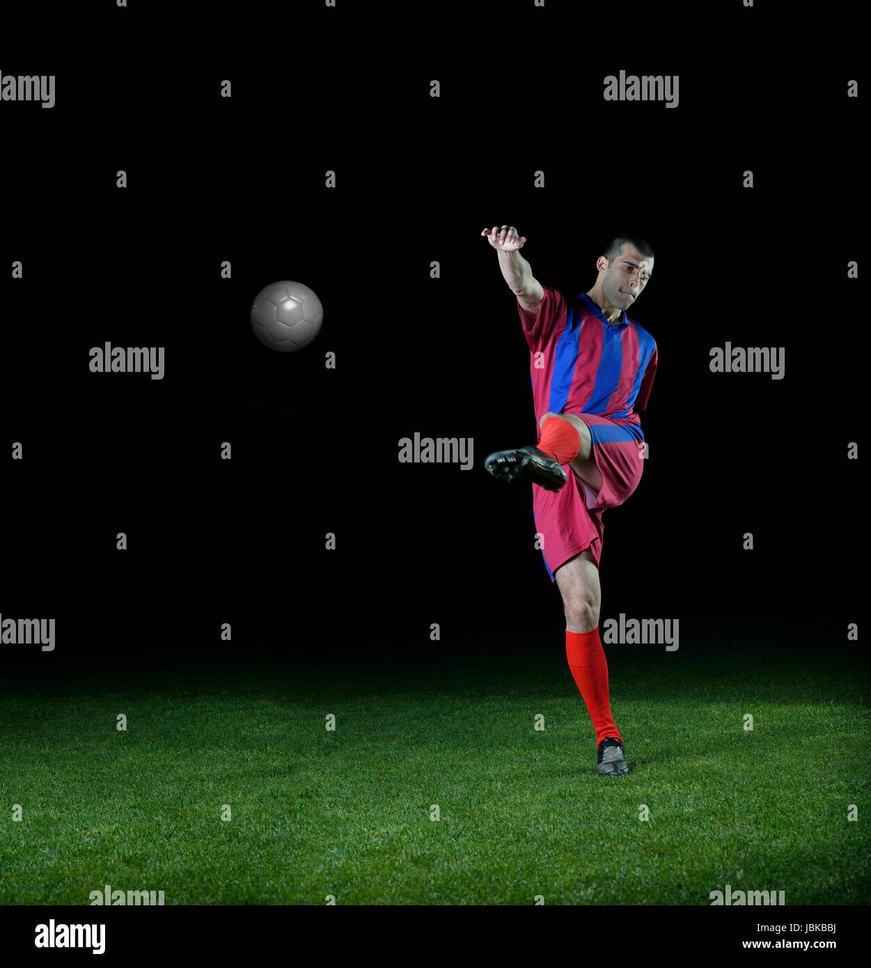 soccer player doing kick with ball on football stadium field isolated ...