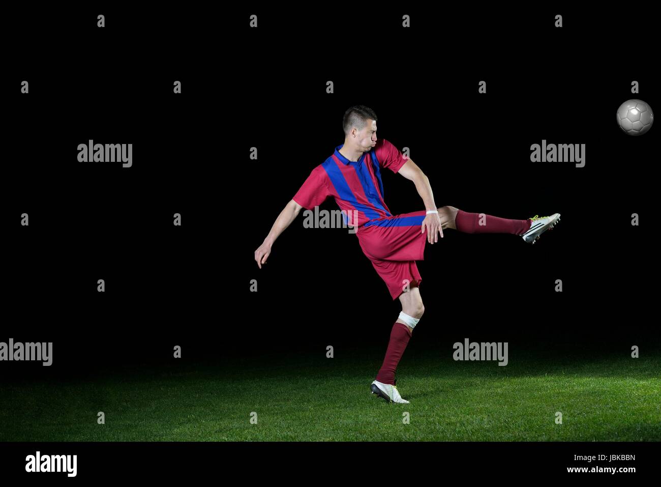soccer player doing kick with ball on football stadium field isolated ...