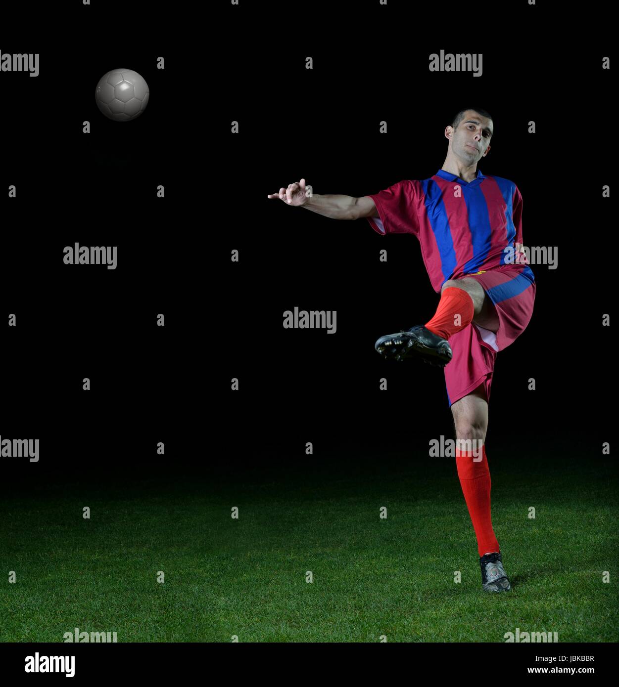 soccer player doing kick with ball on football stadium field isolated ...