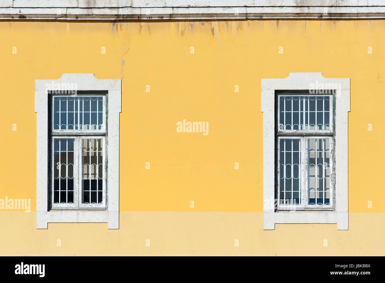 Two white windows on a yellow wall Stock Photo - Alamy