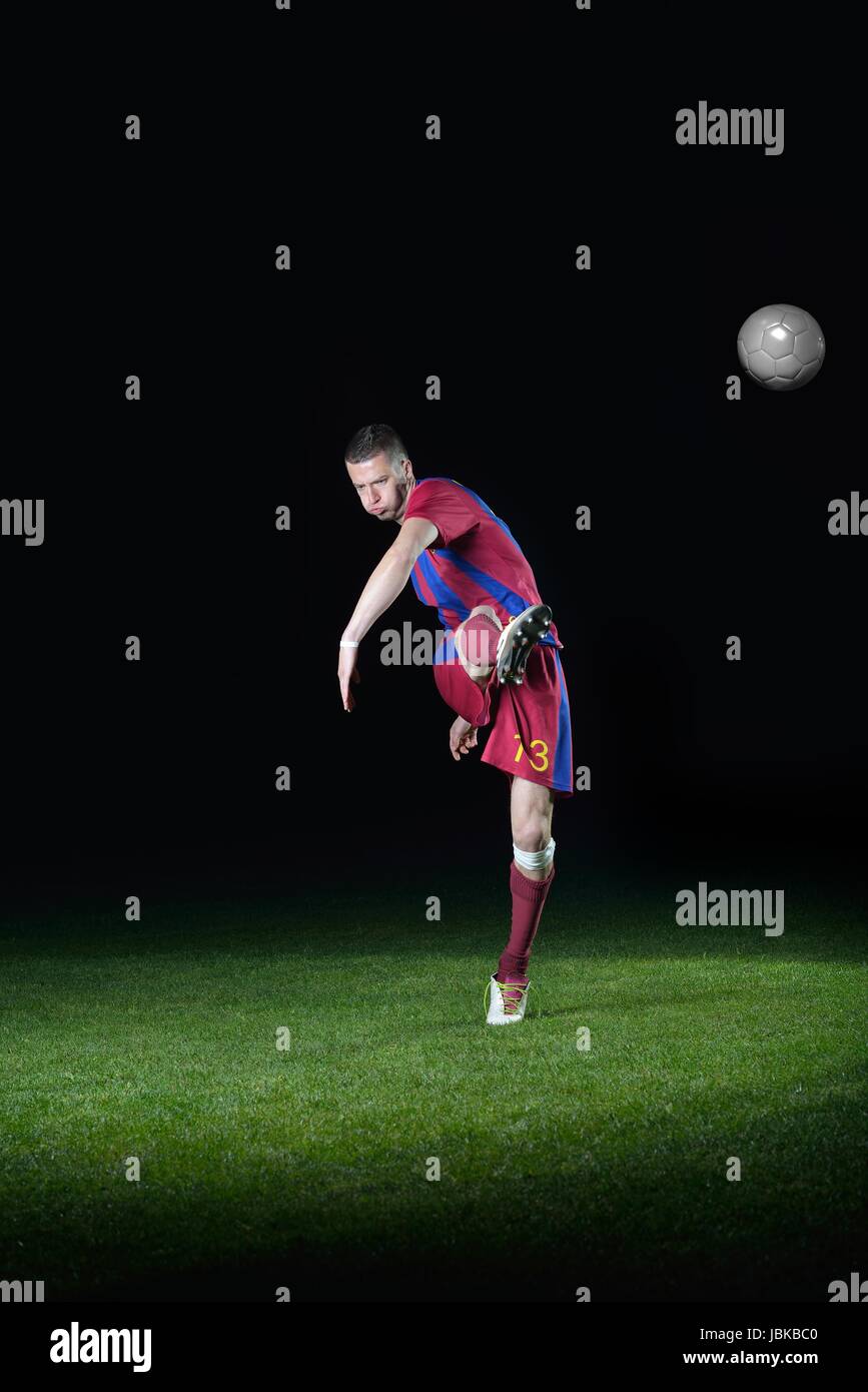 soccer player doing kick with ball on football stadium field isolated ...