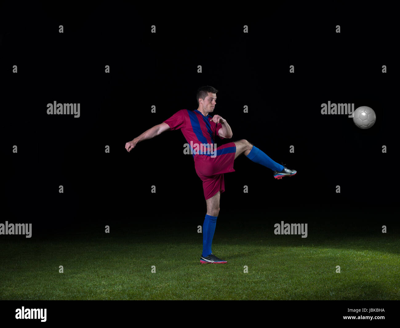 soccer player doing kick with ball on football stadium field isolated on black background Stock ...