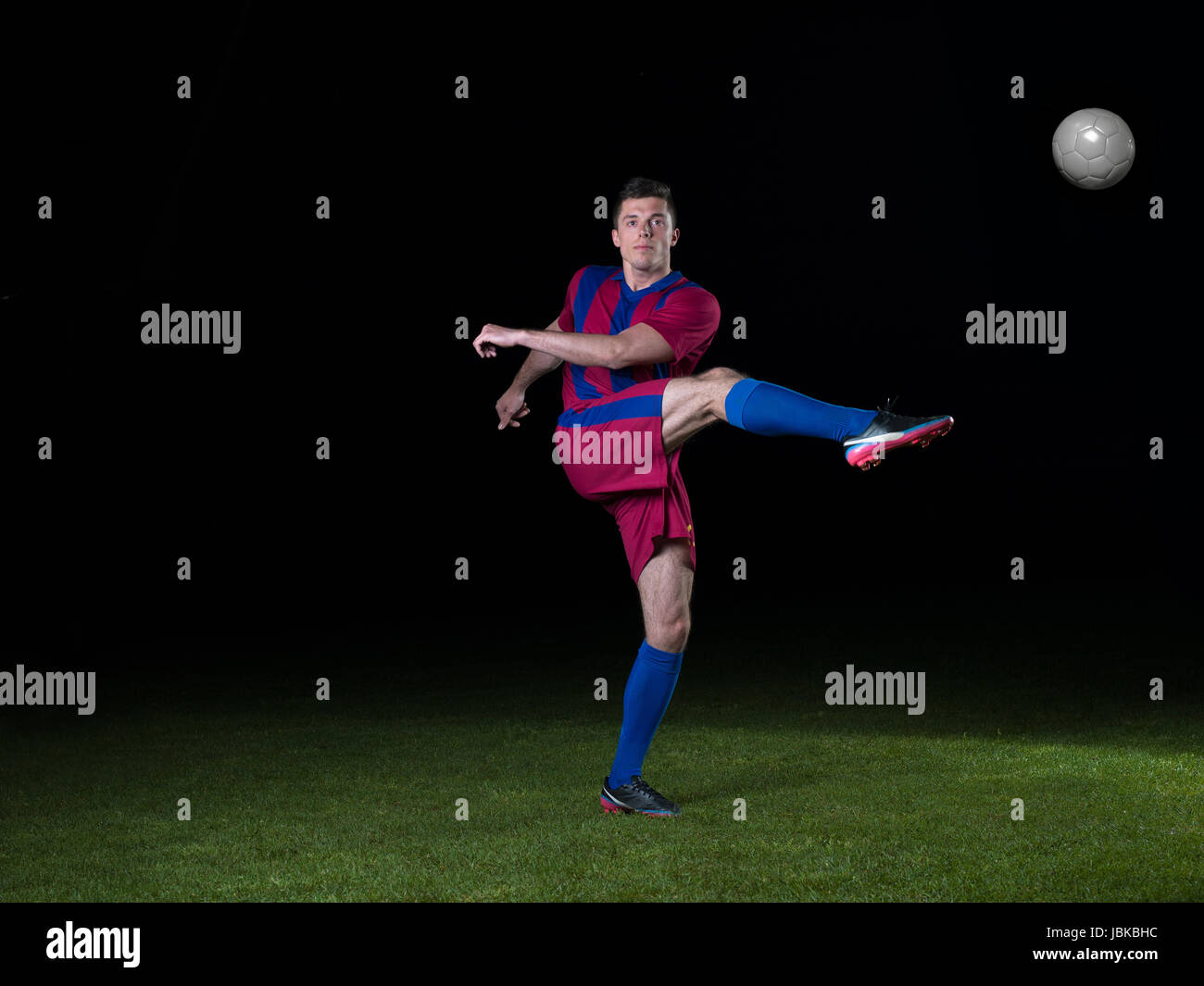 soccer player doing kick with ball on football stadium field isolated ...