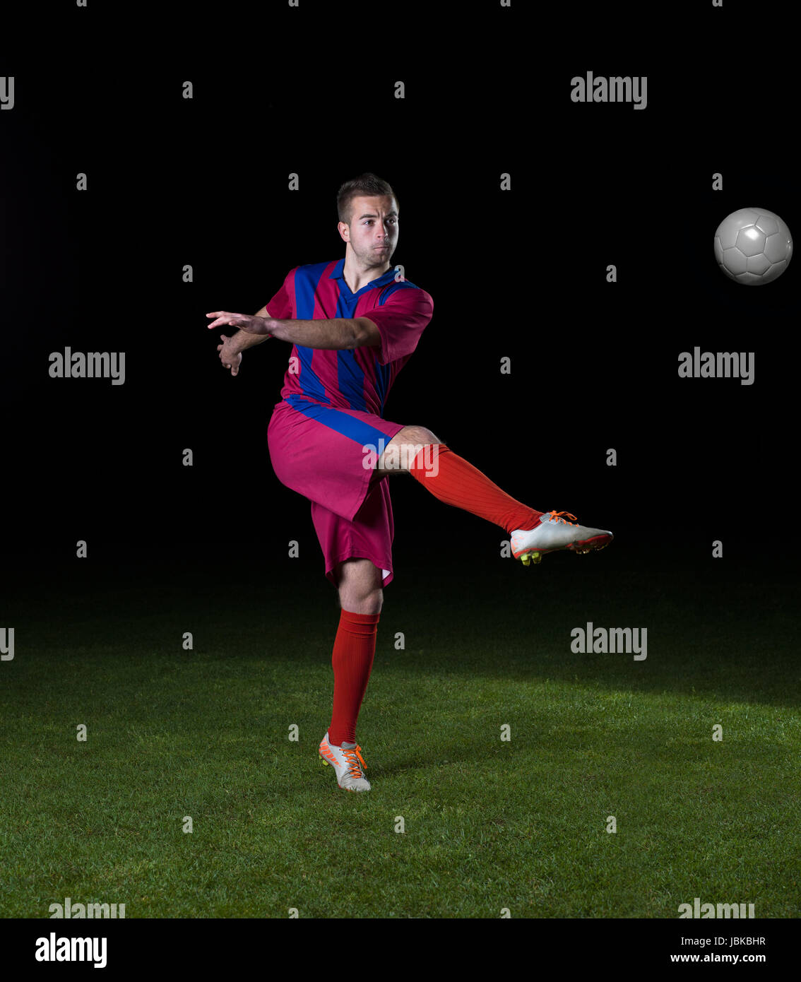 soccer player doing kick with ball on football stadium field isolated ...