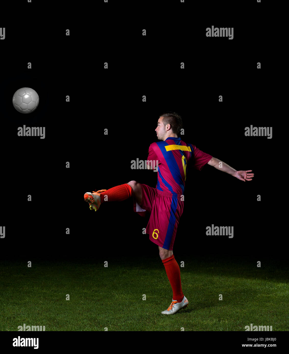 soccer player doing kick with ball on football stadium field isolated ...