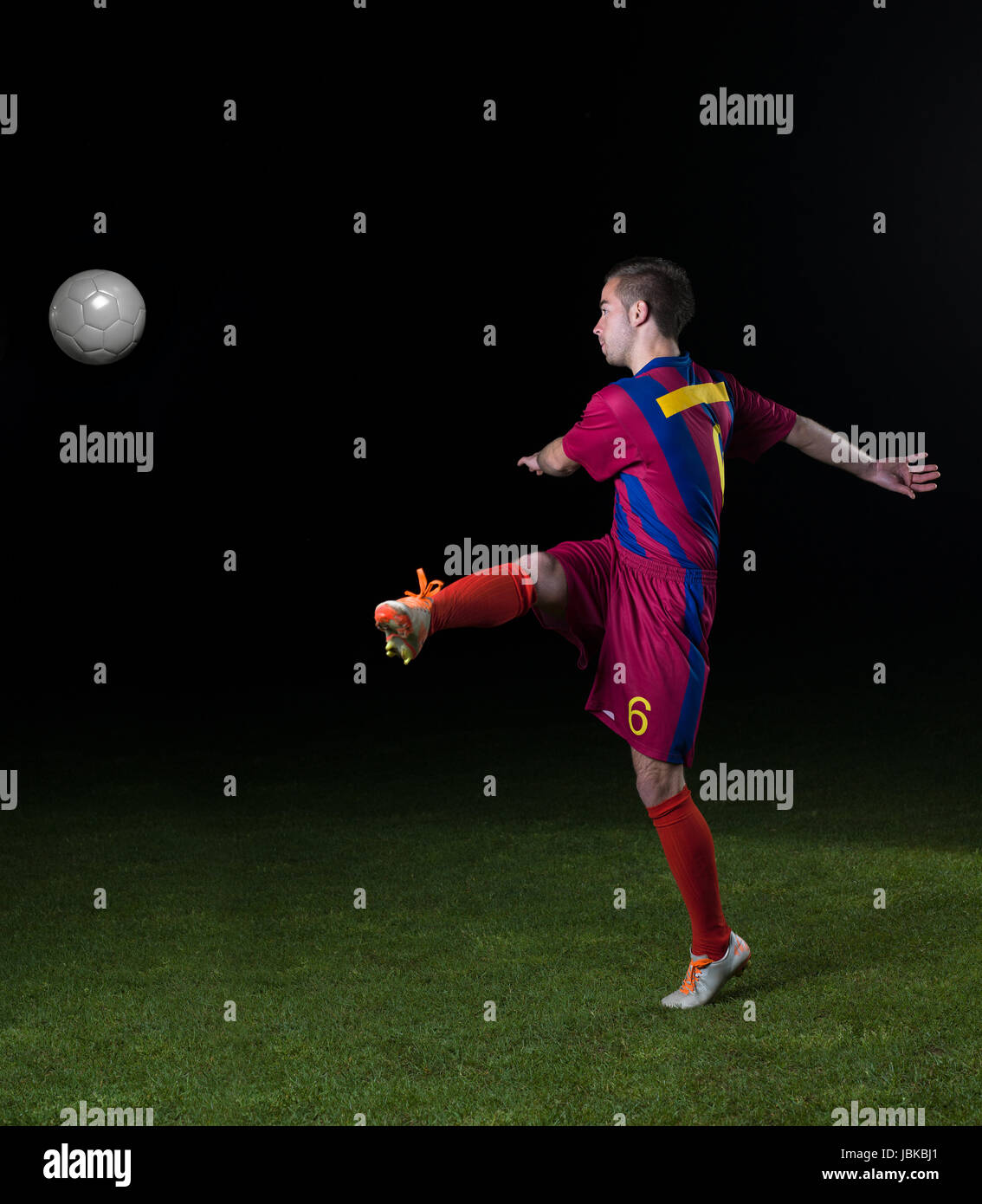 soccer player doing kick with ball on football stadium field isolated ...