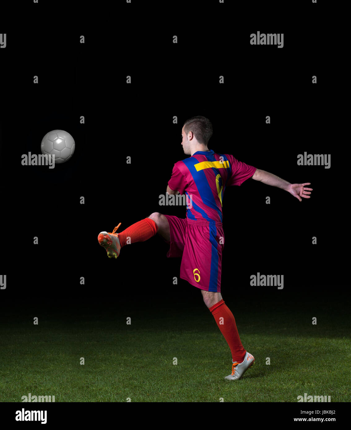 soccer player doing kick with ball on football stadium field isolated ...