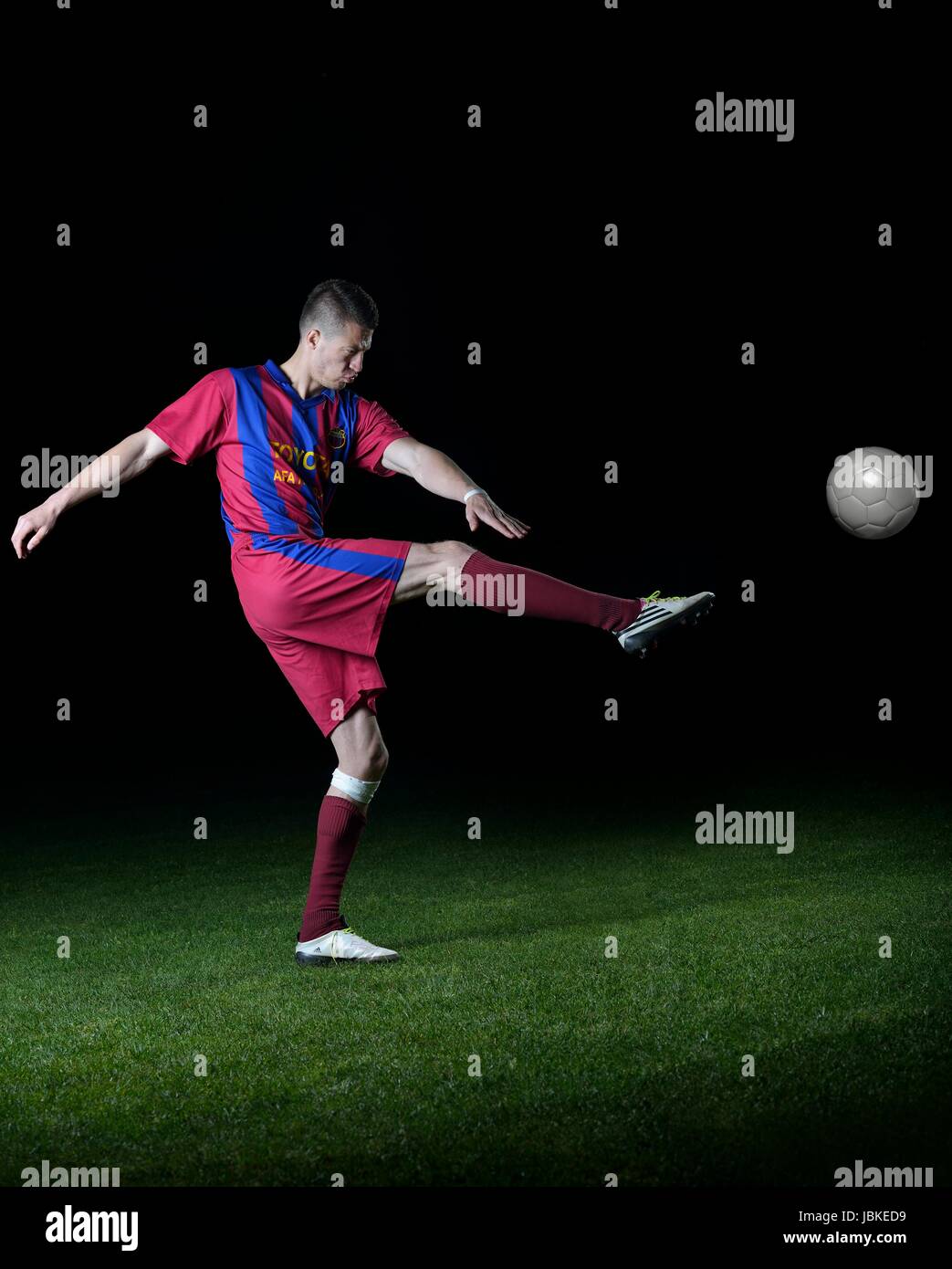 soccer player doing kick with ball on football stadium field isolated ...