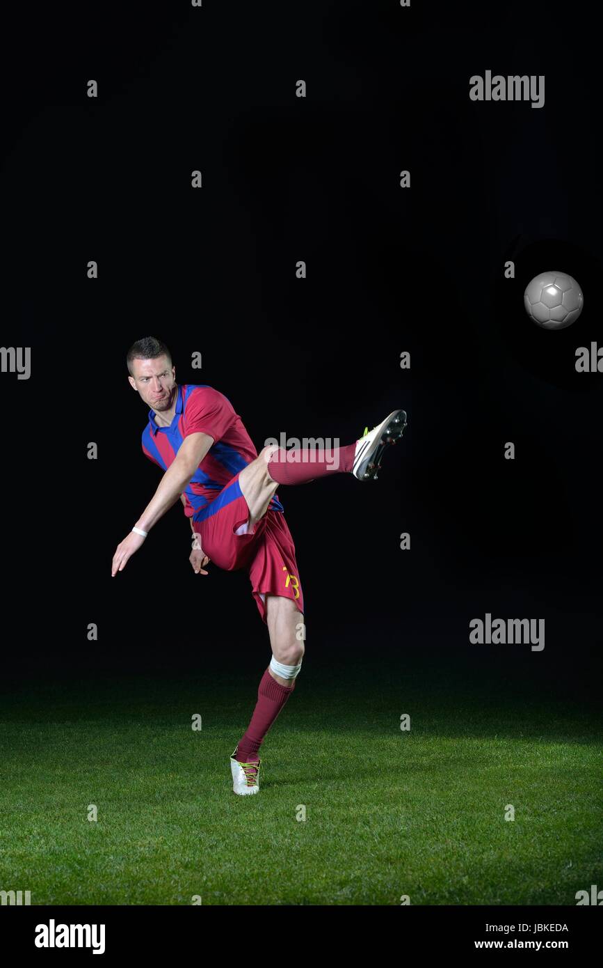 soccer player doing kick with ball on football stadium field isolated on black background Stock ...