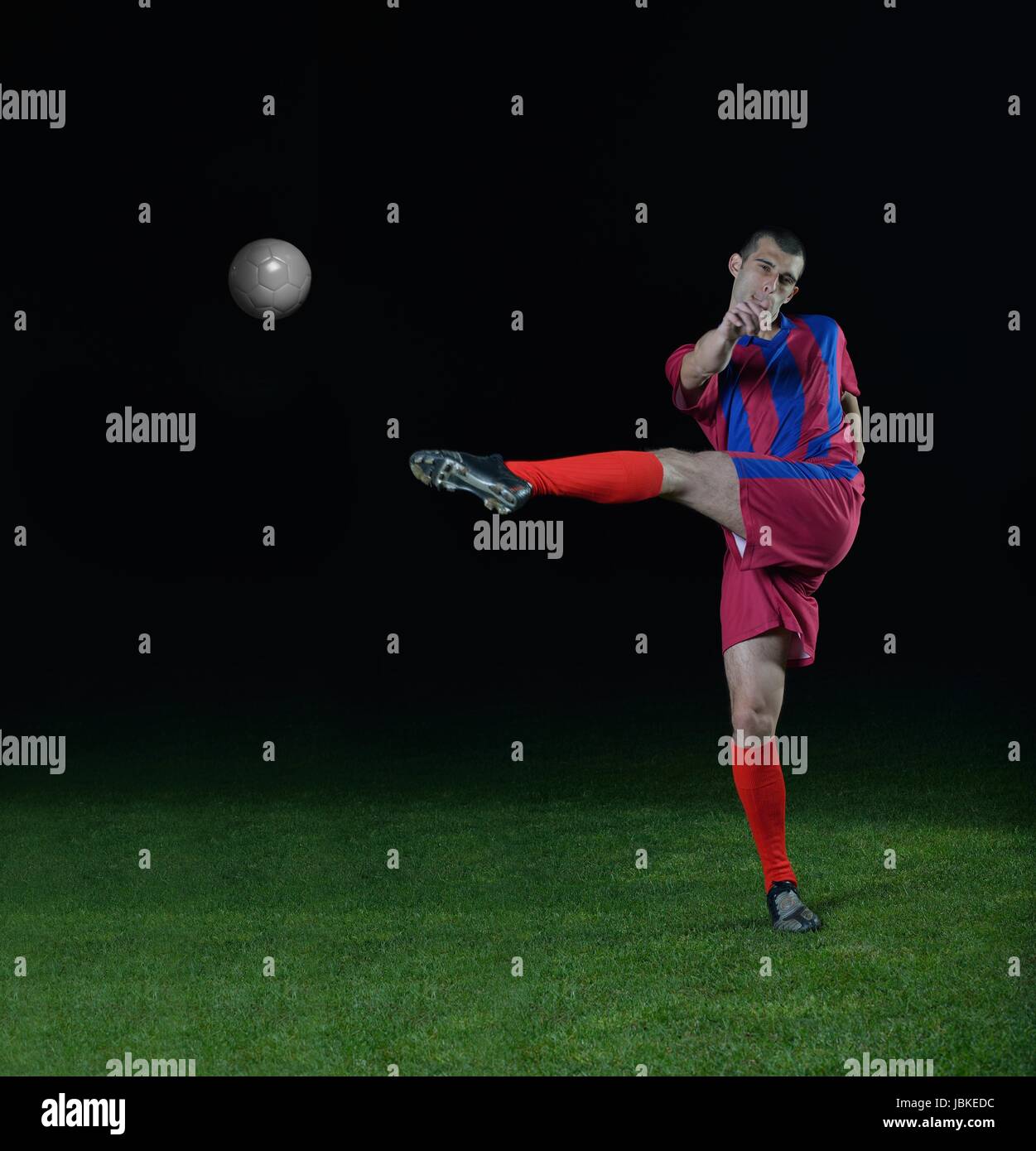 soccer player doing kick with ball on football stadium field isolated on black background Stock ...