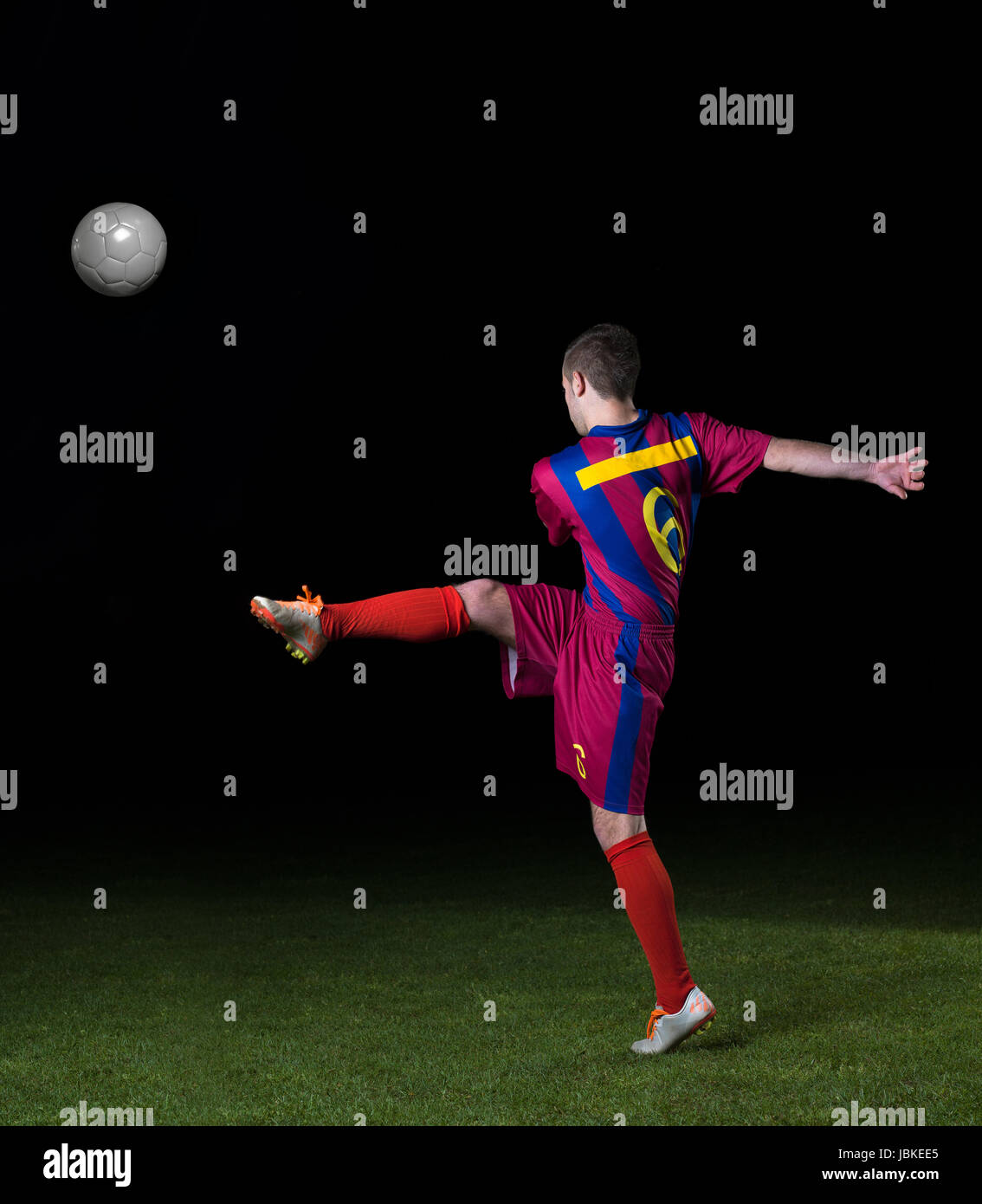 soccer player doing kick with ball on football stadium field isolated ...