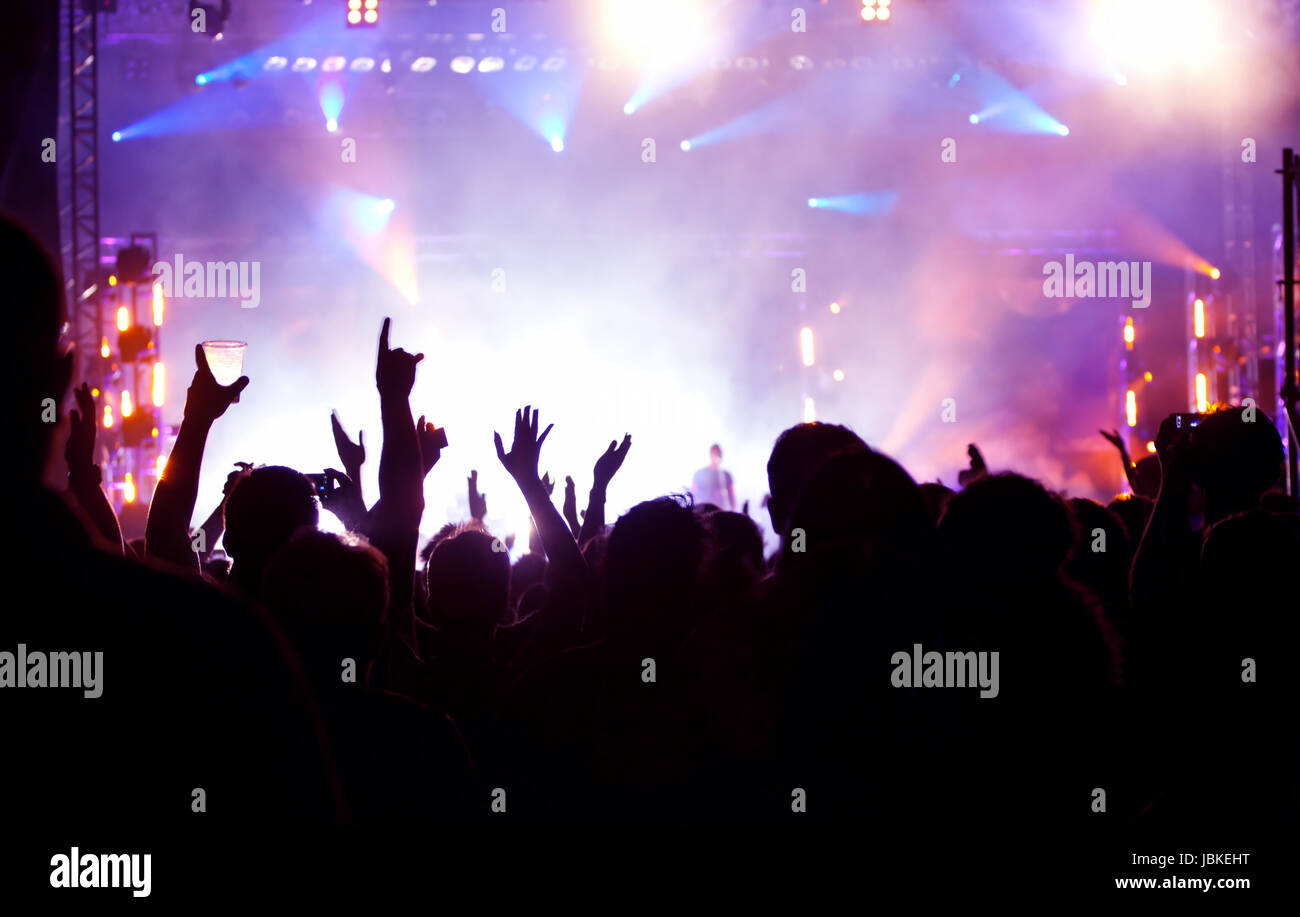 Cheering crowd in front of bright colorful stage lights Stock Photo - Alamy