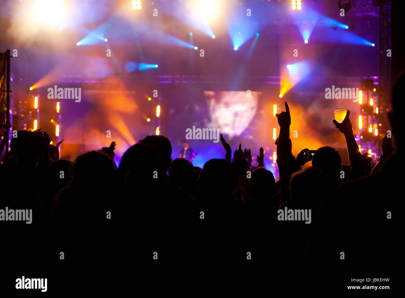 Cheering crowd in front of bright colorful stage lights Stock Photo - Alamy