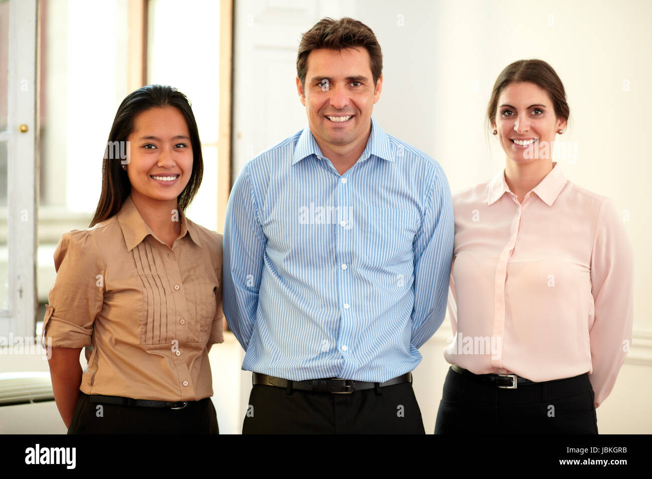 Portrait of ethnic professional coworkers smiling at you while standing ...
