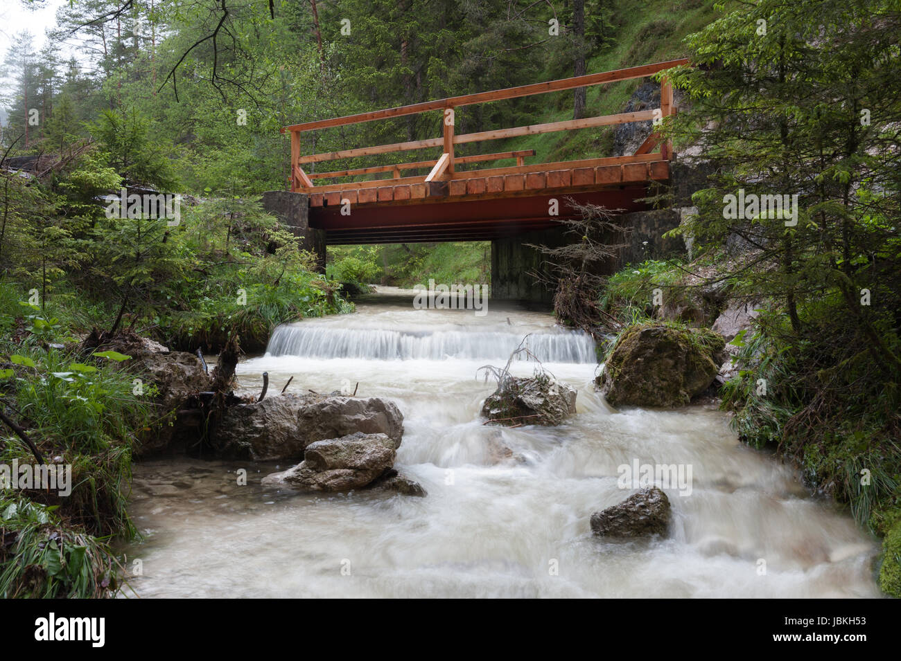 Wooden bridge over flowing water Stock Photo - Alamy