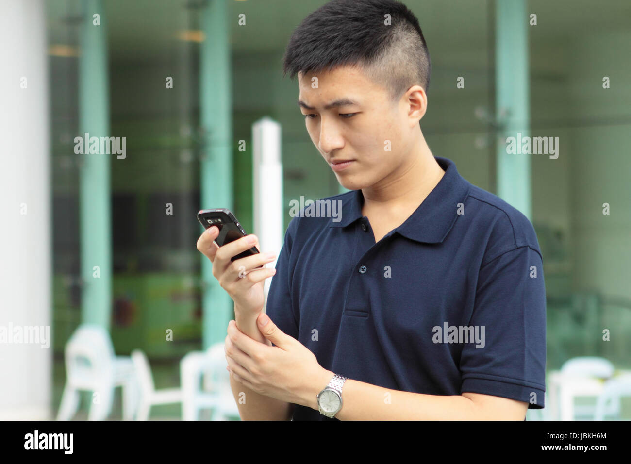 Asian man typing a message on mobile phone Stock Photo - Alamy