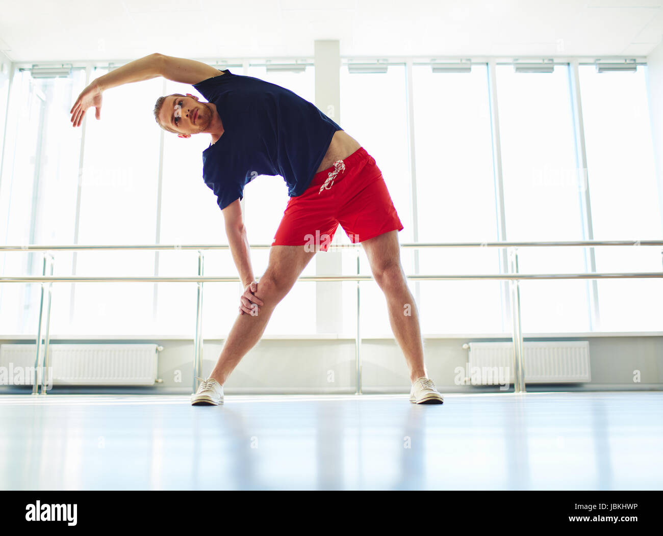 Portrait of young man doing physical exercise in gym Stock Photo - Alamy