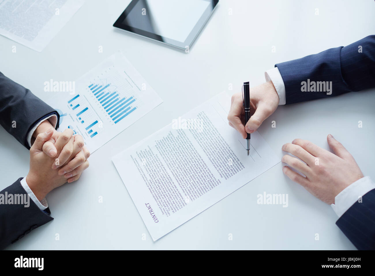 Two managers signing a contract Stock Photo - Alamy