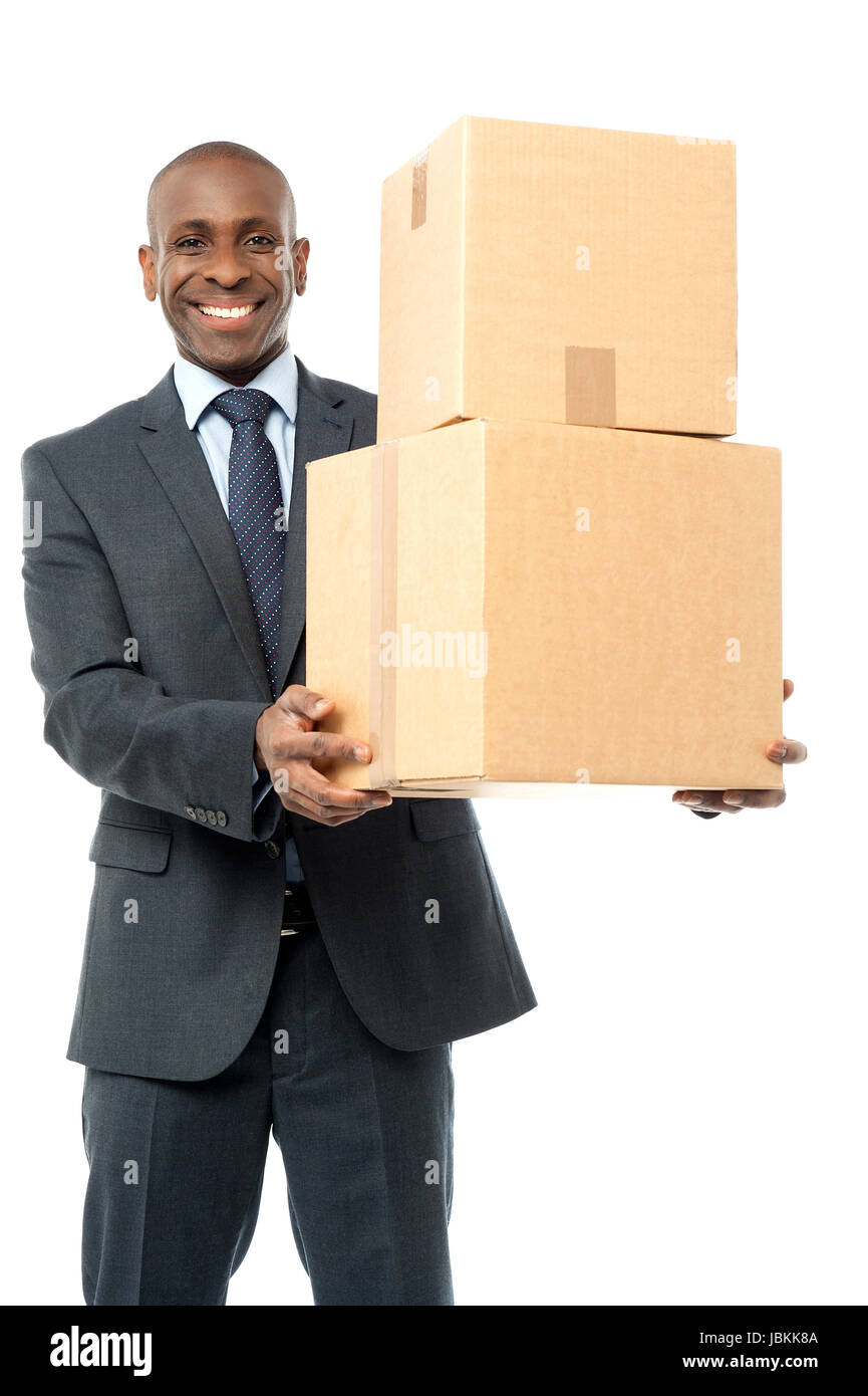 Smiling corporate man holding stack of boxes Stock Photo - Alamy