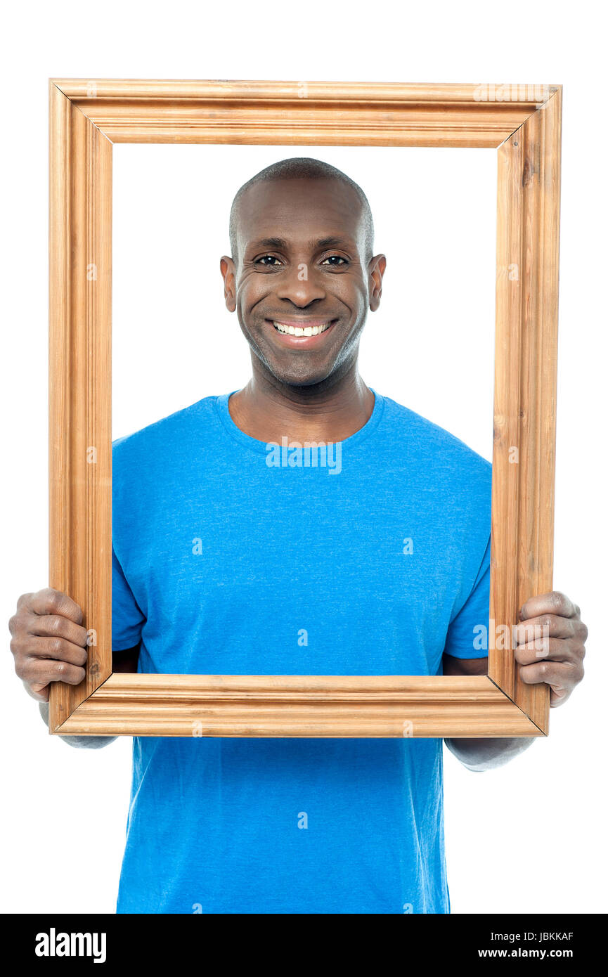 Happy man standing behind wooden picture frame Stock Photo - Alamy