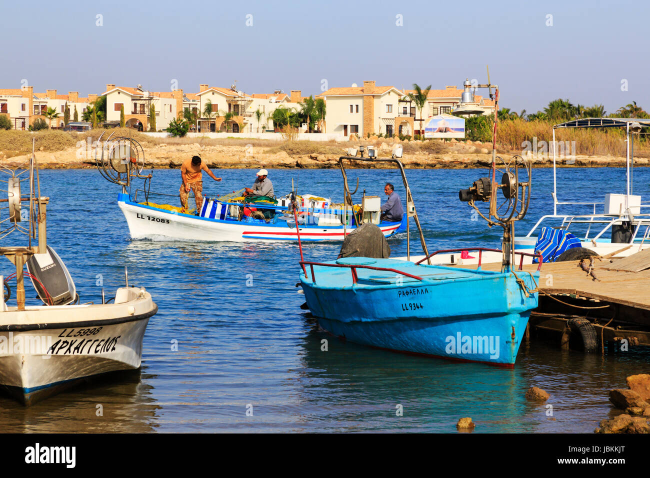 A traditional Cypriot fishing boat and crew return to Potamos Creek ...