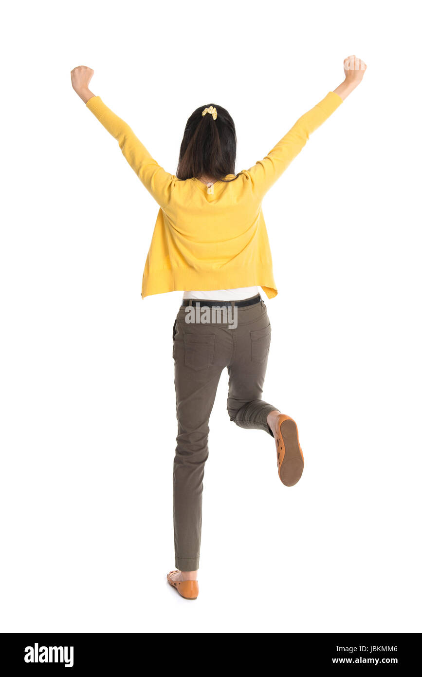 Rear view or back of an Asian girl arms up happy jumping around, full ...